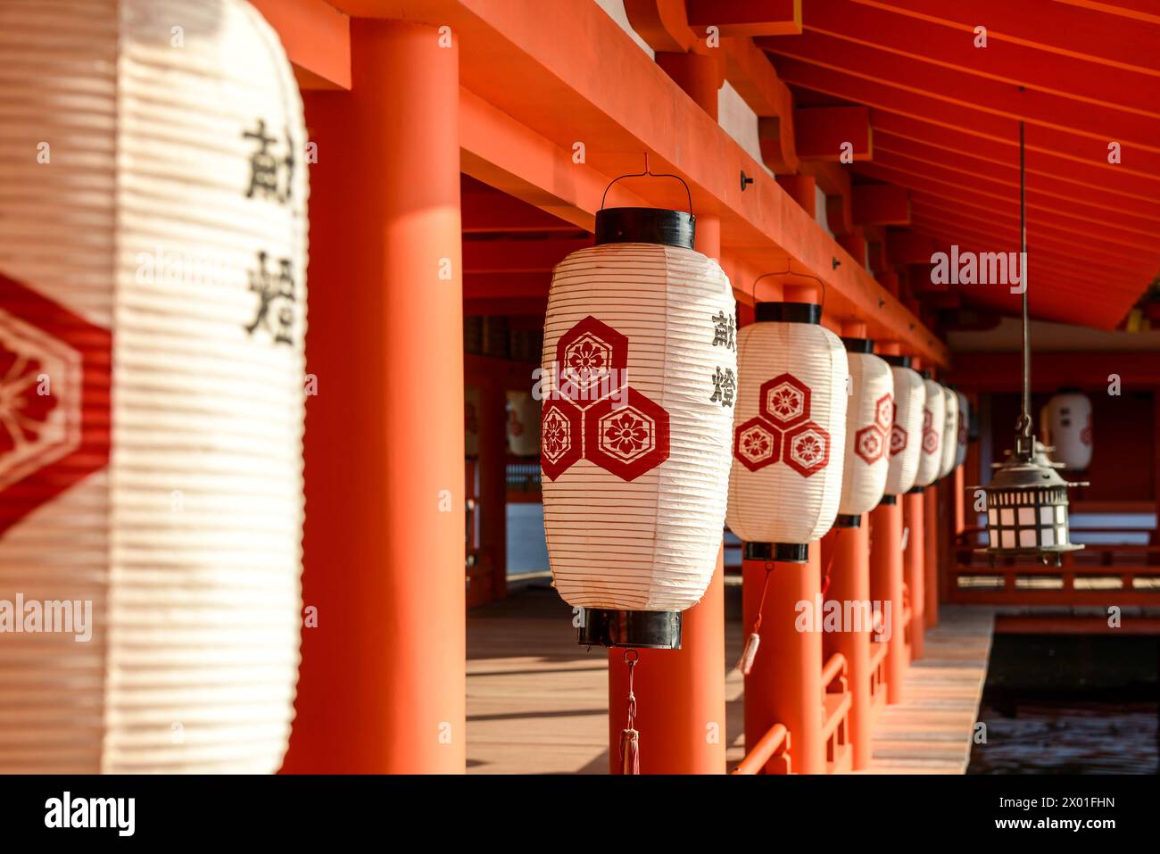 Paper lanterns hanging from wooden eaves of a walkway at Itsukushima ...