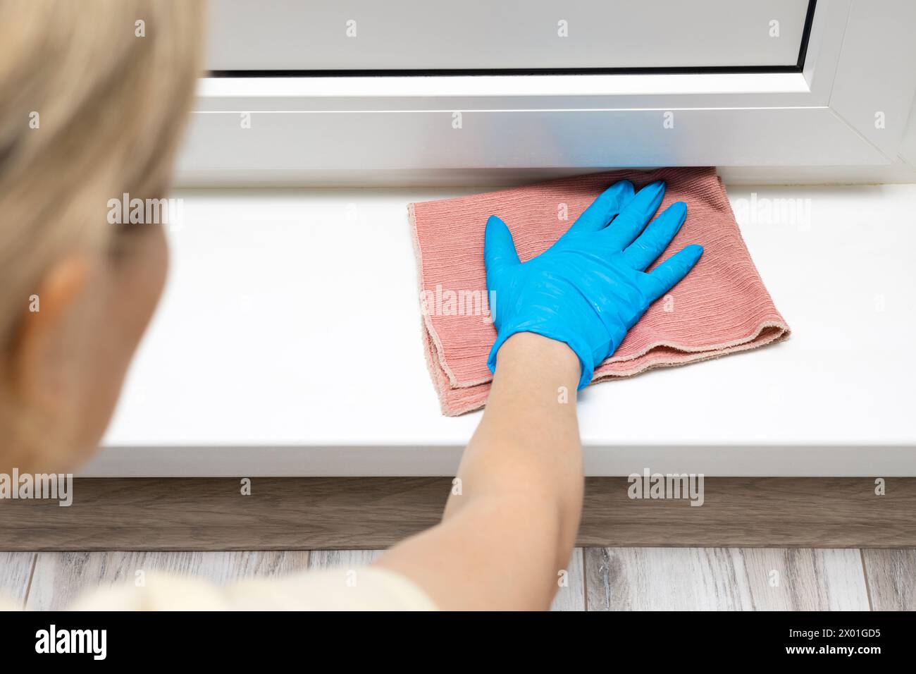 housewife wipes the plastic threshold of the balcony with a rag. wet ...
