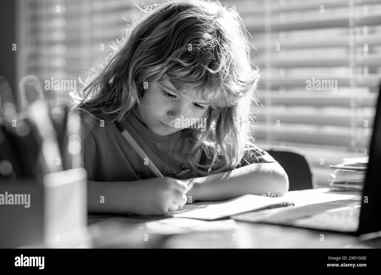 Child writing at school. Portrait of school kid boy siting on table ...