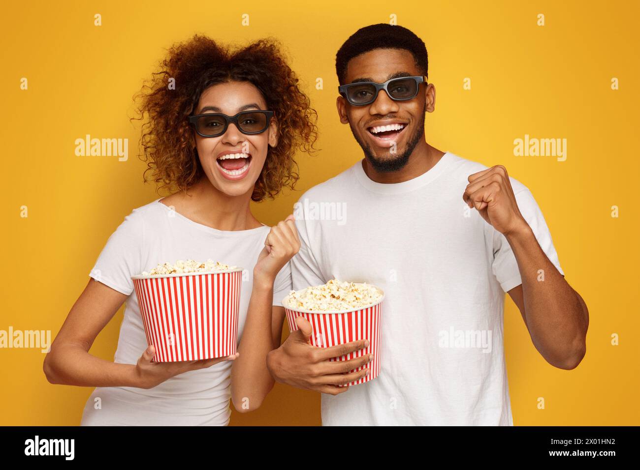 Laughing couple in 3d glasses holding buckets of popcorn Stock Photo - Alamy