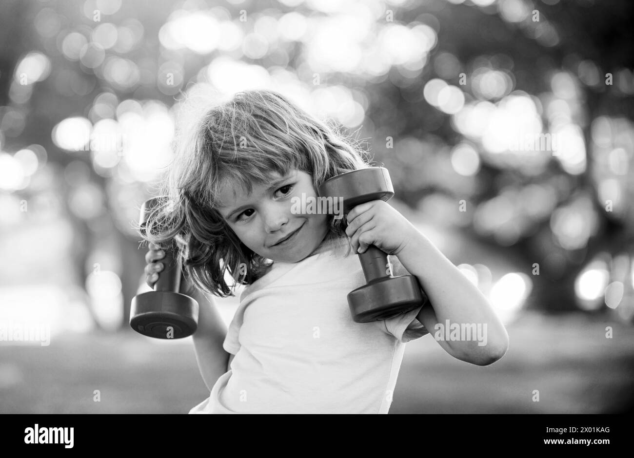 Sporty activity. Boy workout with dumbbell in park. Kid sport. Child ...