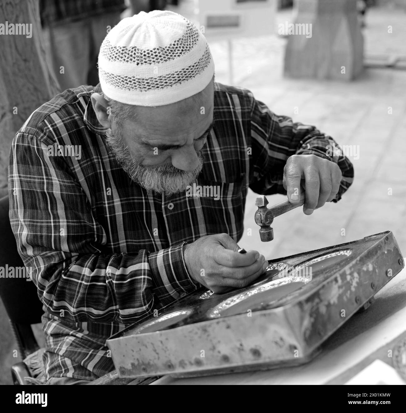 Coppersmith at work outside his workshop (black and white image) in ...