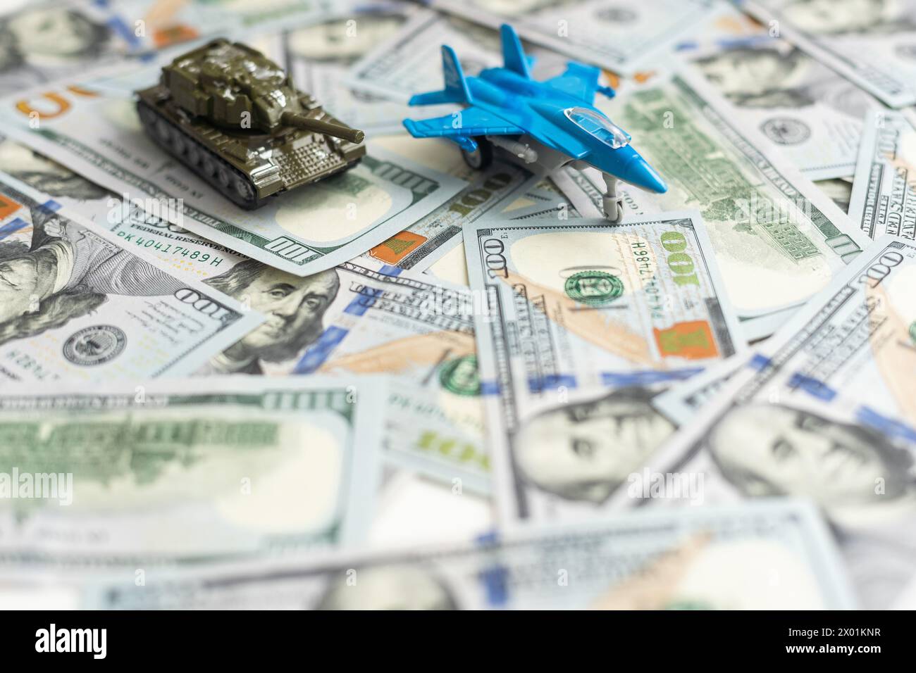 Toy tank on US hundred dollar bills banknotes close up. The concept of ...