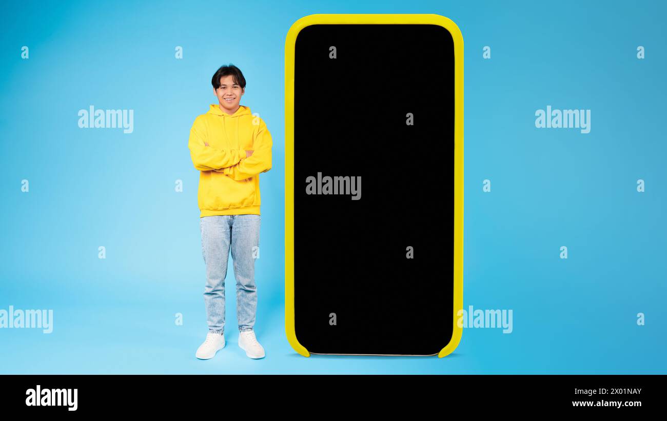 Guy with crossed arms next to smartphone prop Stock Photo - Alamy