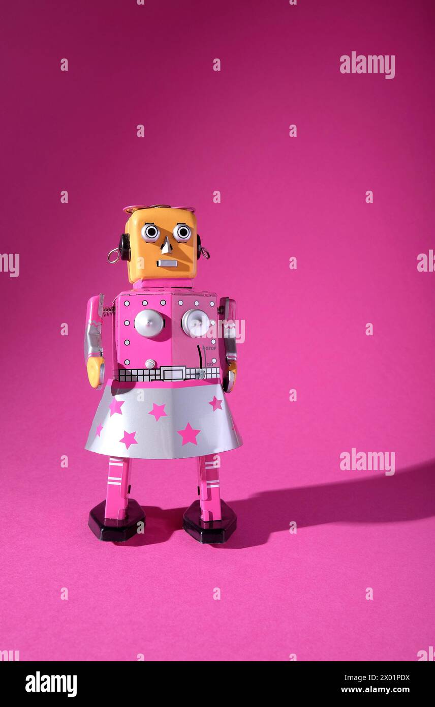 female robot metal toy on bright pink background Stock Photo - Alamy