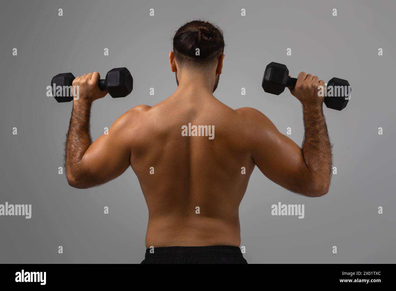 Back view of a muscular man with dumbbells in gym Stock Photo - Alamy