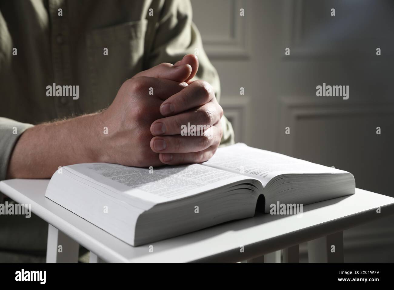 Religion. Christian man praying over Bible indoors, closeup Stock Photo ...