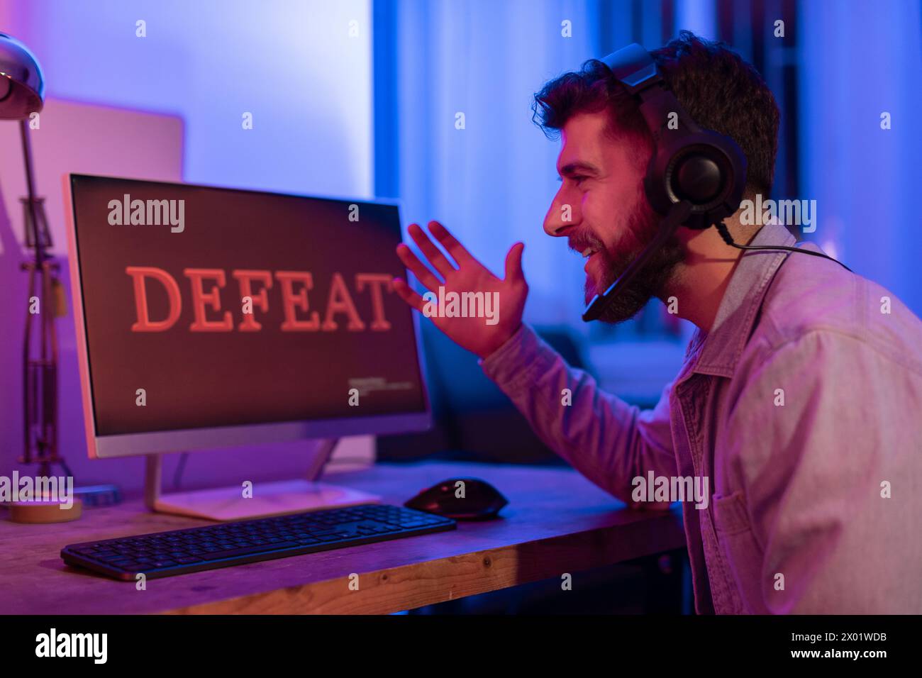 Gamer with defeat message on computer screen Stock Photo - Alamy