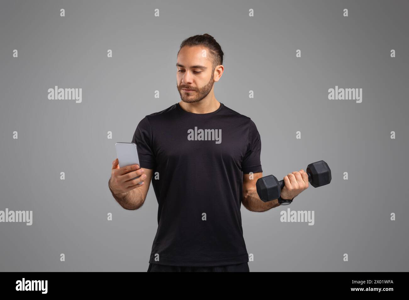 Focused man multitasking with smartphone on grey background Stock Photo ...