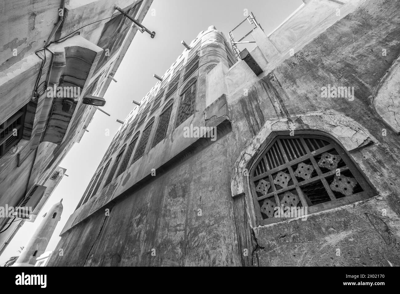 A monochrome, filtered image of an ogee arched window with a wooden ...