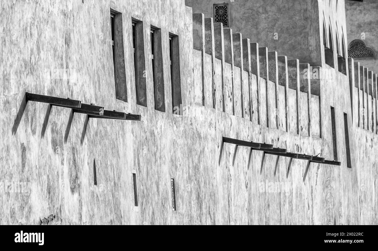 A monochrome view of wooden drains and windows along a wall of a ...