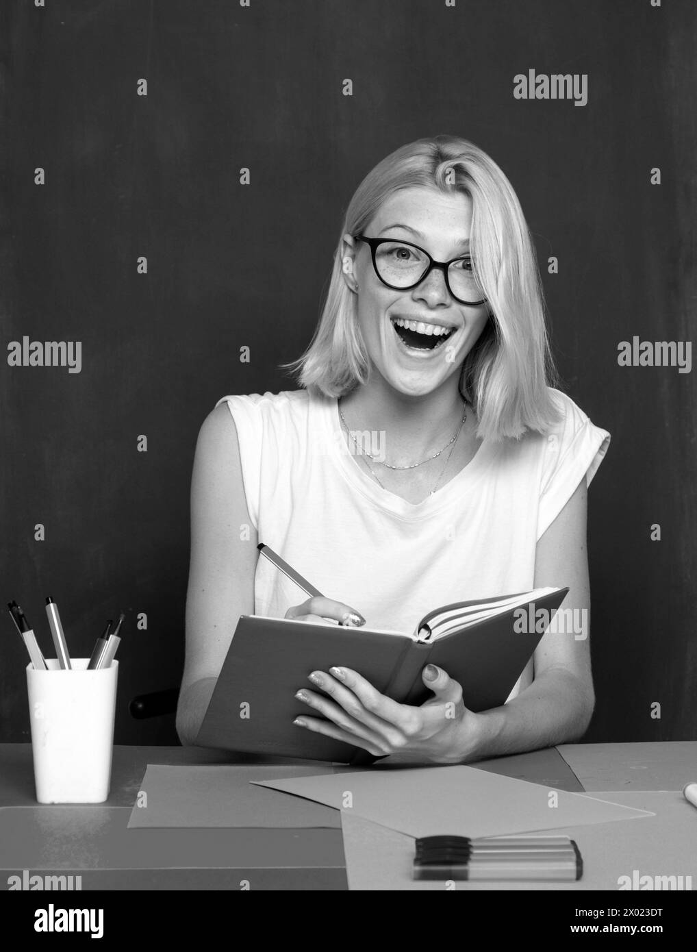 Female teacher smiling and teaching in classroom at school or ...