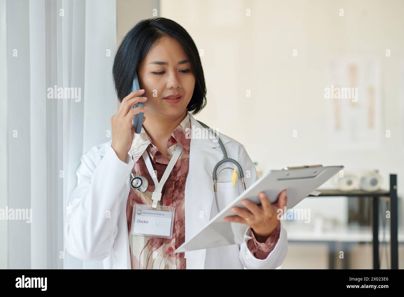 Portrait of physician reading medical history and calling patient Stock ...