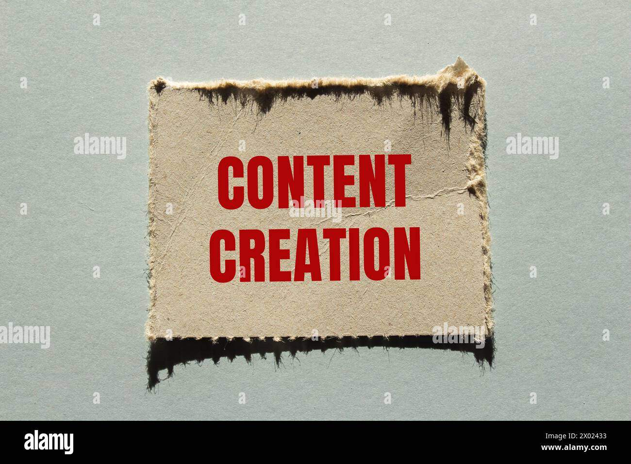 Content creation words written on ripped paper with gray background ...