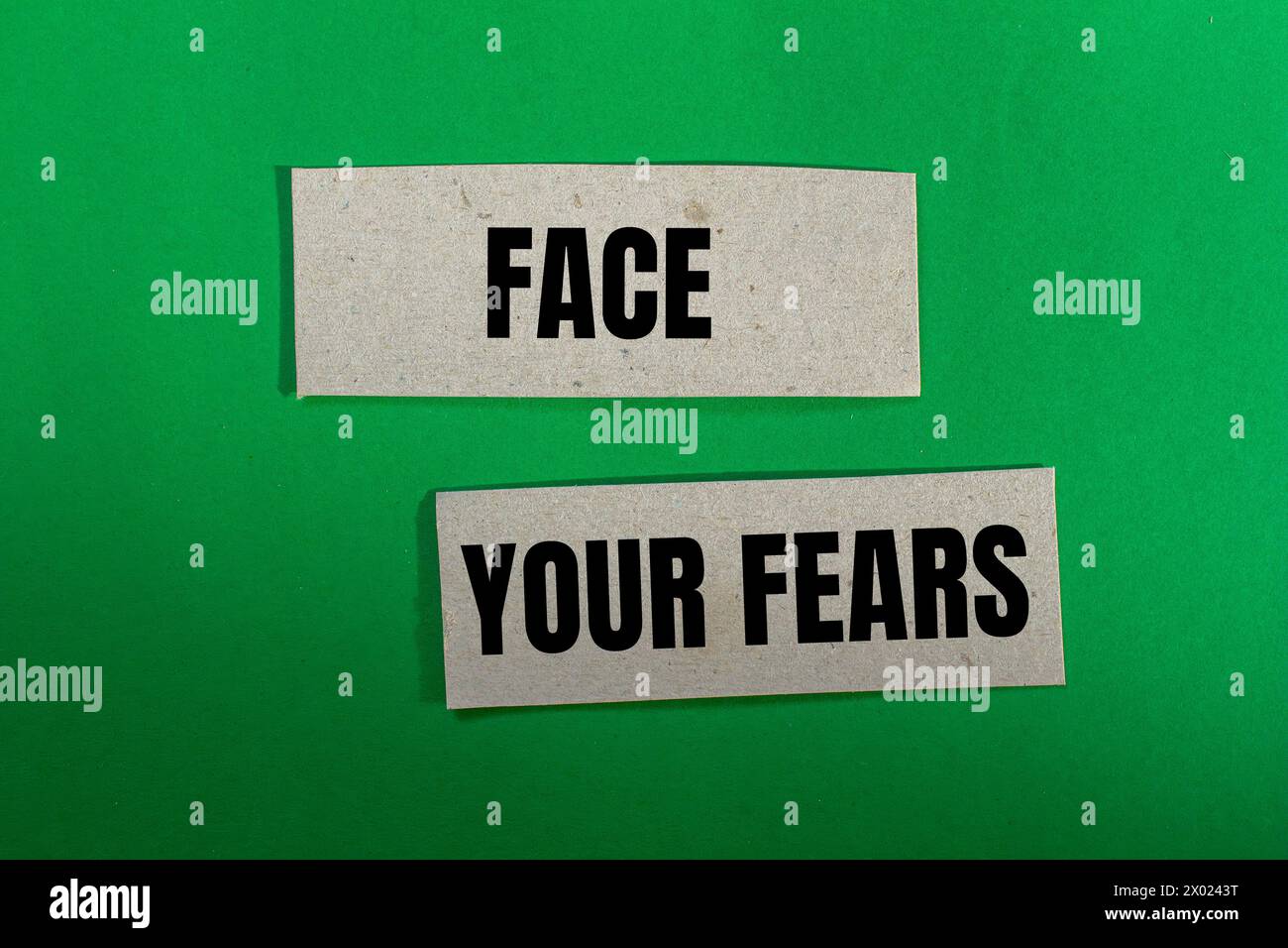 Face your fears words written on paper pieces with green background ...