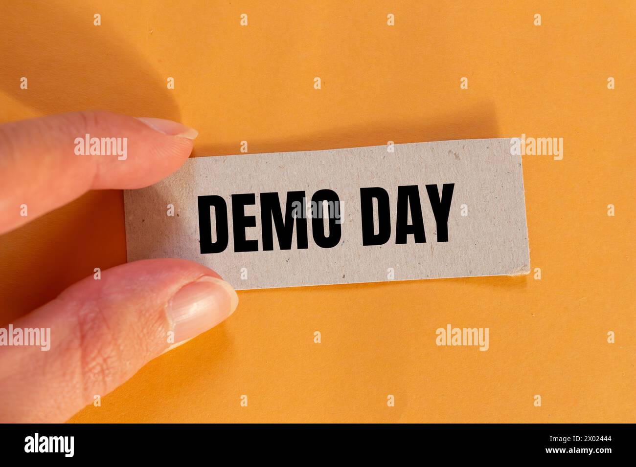Demo day words written on paper piece with orange background ...