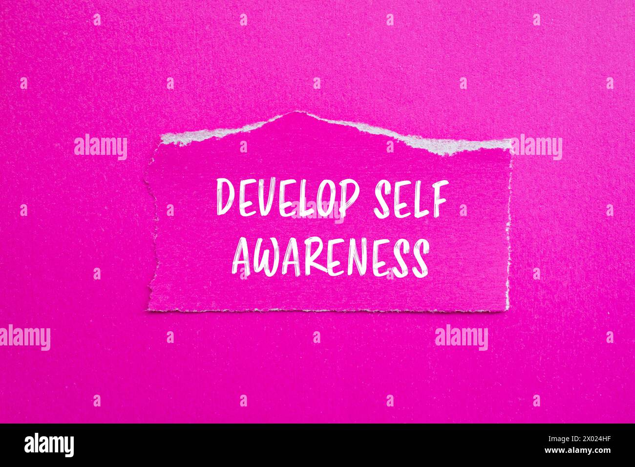 Develop self awareness words written on ripped paper with pink ...