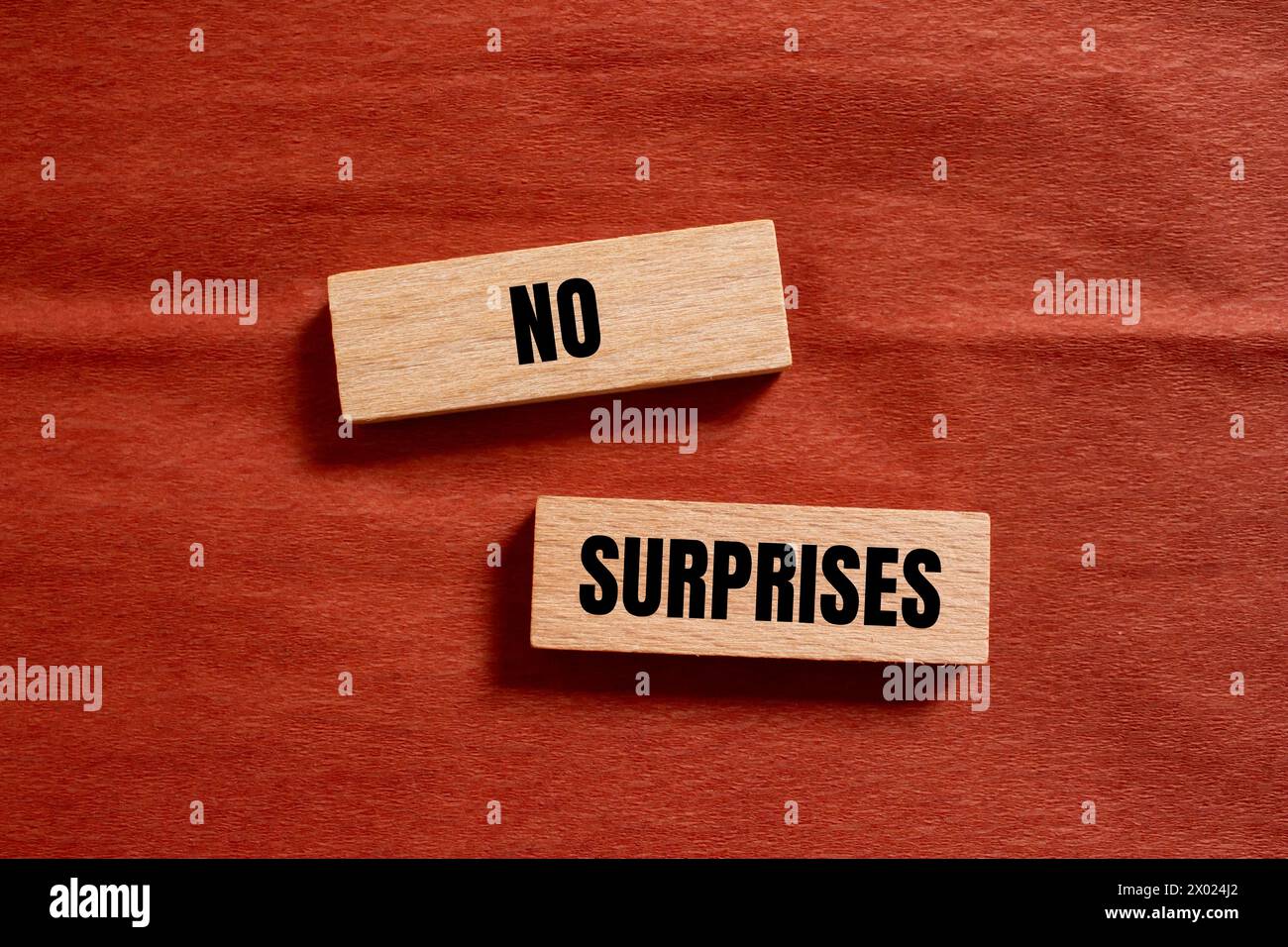No surprises words written on wooden blocks with brown background ...
