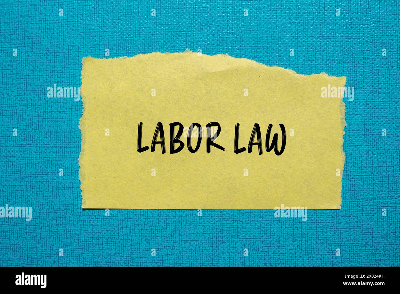 Labor law words written on ripped paper with blue background ...