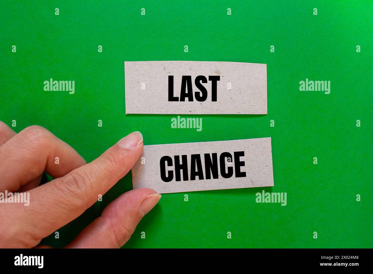 Last chance words written on ripped paper with green background ...