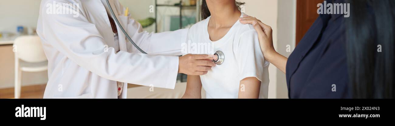 Header with mother touching shoulder of daughter during medical ...