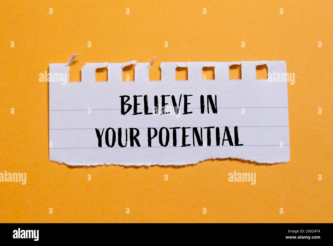 Believe in your potential words written on ripped paper with orange ...