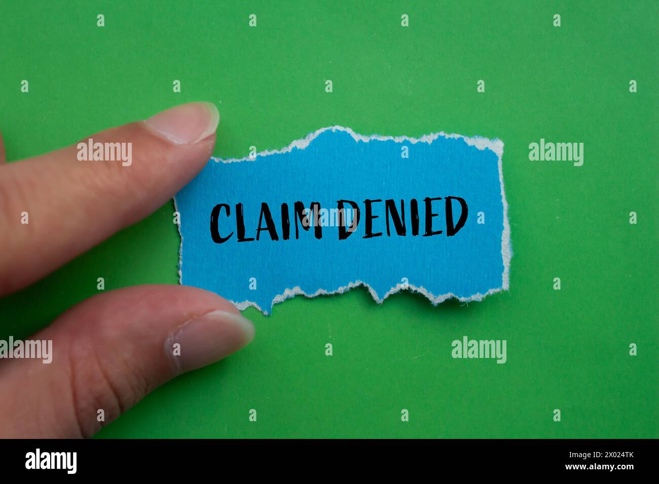 Claim denied words written on ripped paper with green background ...