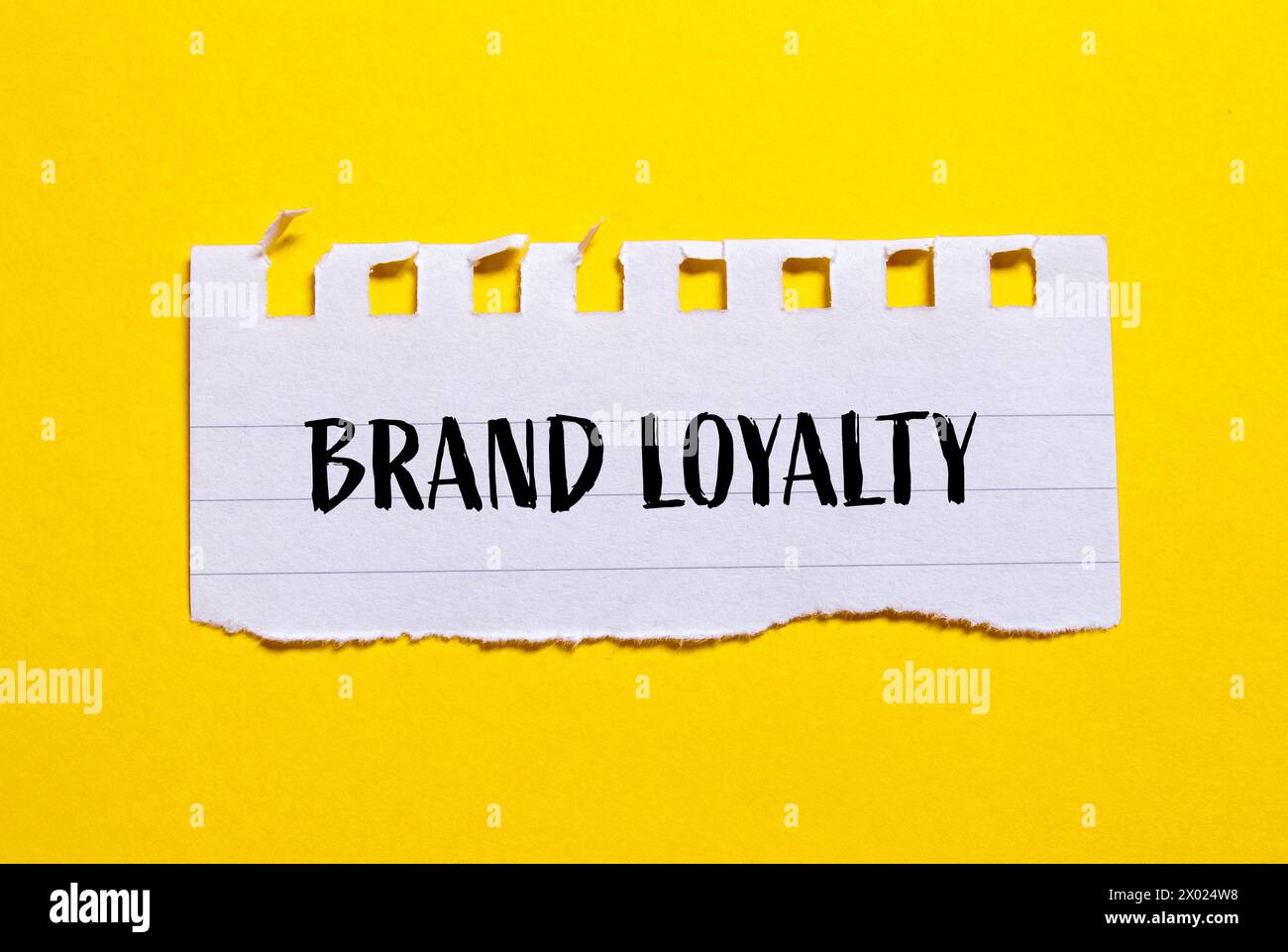 Brand loyalty words written on ripped paper with yellow background ...