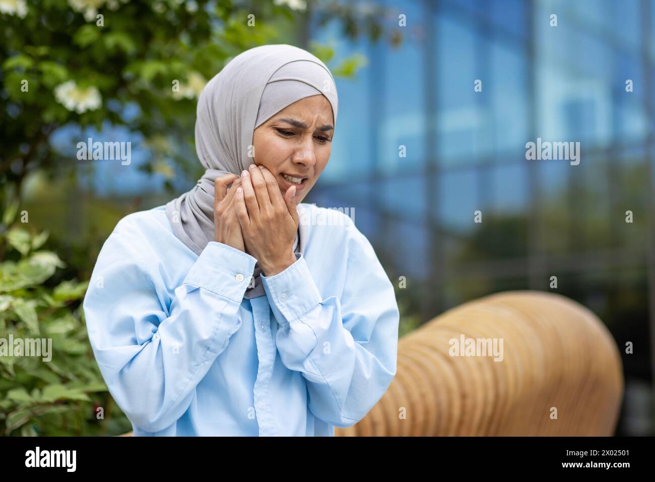 Woman touching cheek squinting wearing hi-res stock photography and ...