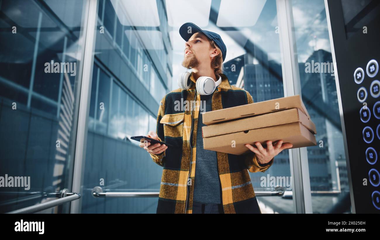 Young Food Delivery Person Riding Glass Elevator in Modern Office ...