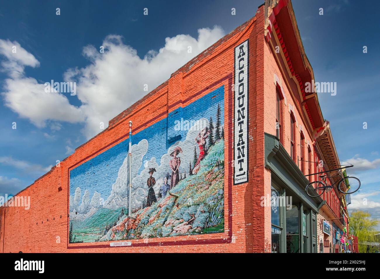 A vibrant mural of a mountain landscape adorns a historic building ...