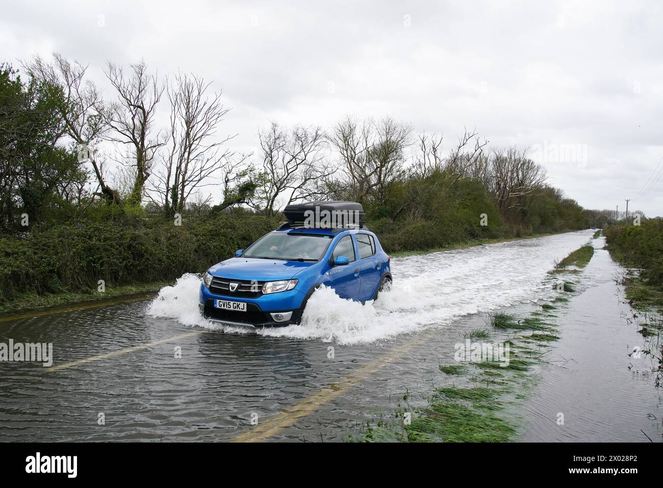 A car drives through flood water in Littlehampton, West Sussex, after ...