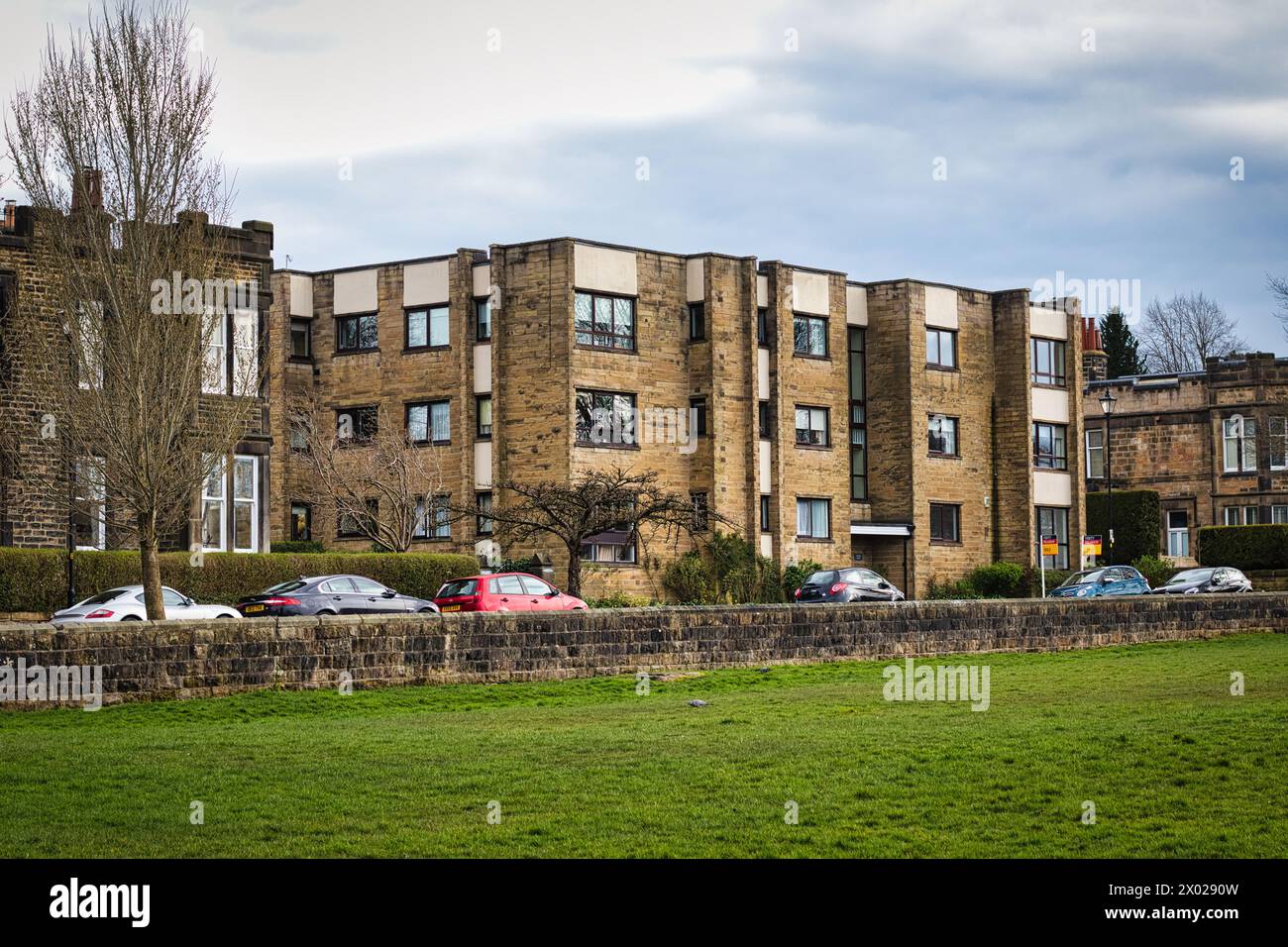 Modern residential apartment buildings with parked cars in front ...