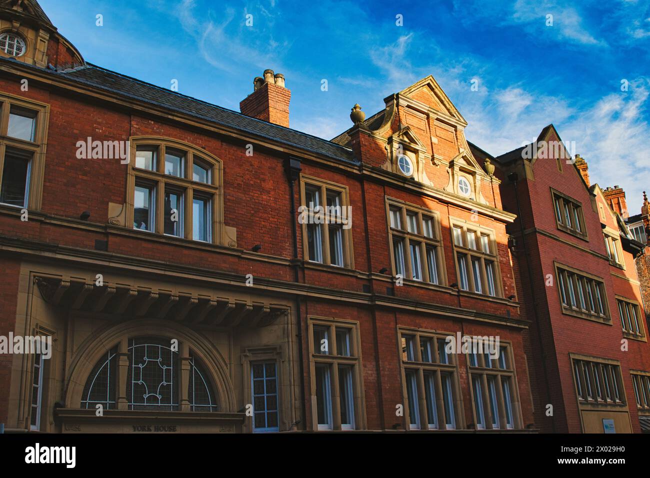 Traditional red brick building with ornate windows under a clear blue ...