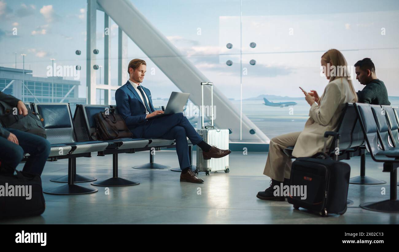 Busy Airport Terminal: Handsome Businessman Working on Laptop Computer ...