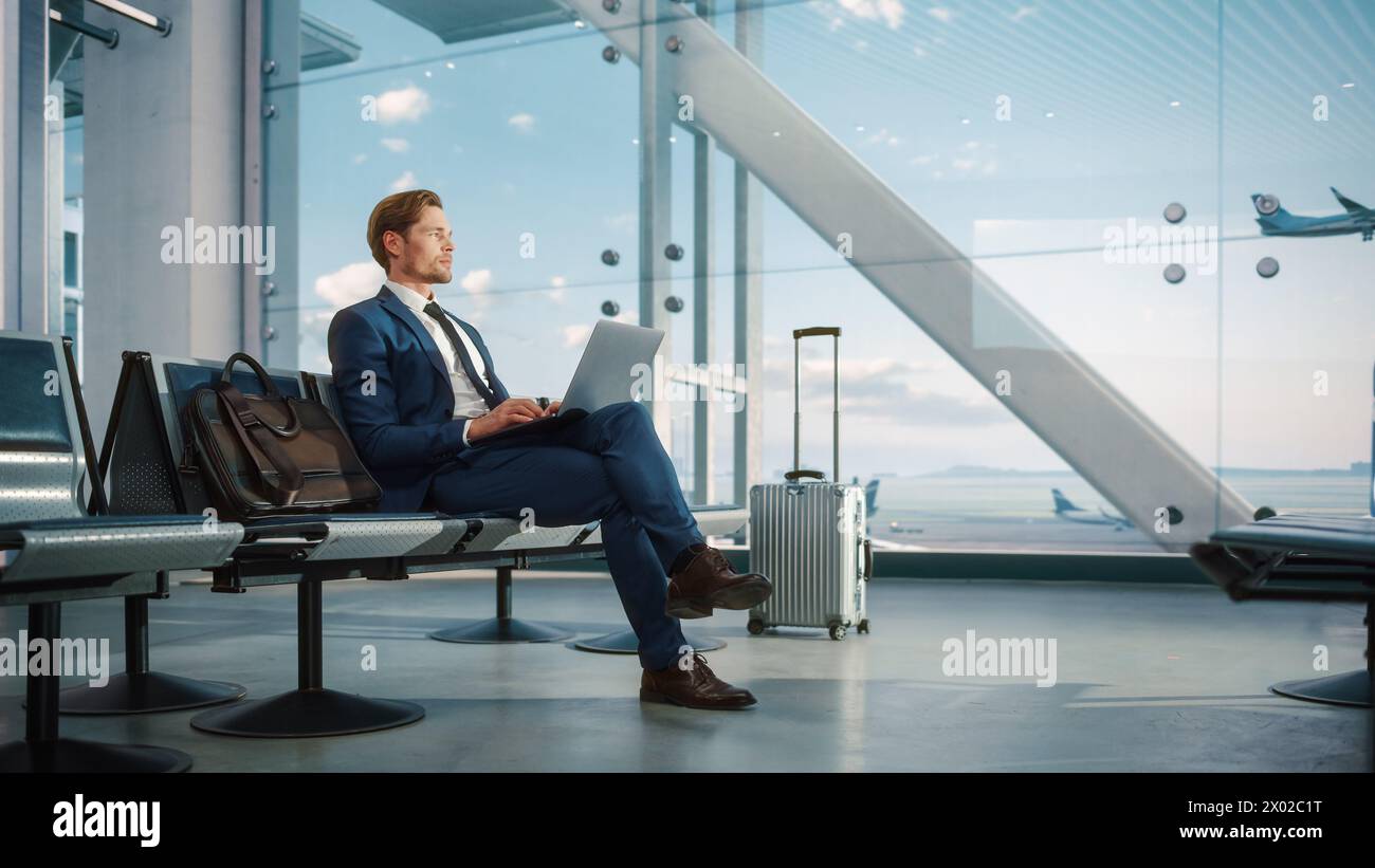 Airport Terminal: Businessman Uses Laptop Computer, Waiting for Flight ...