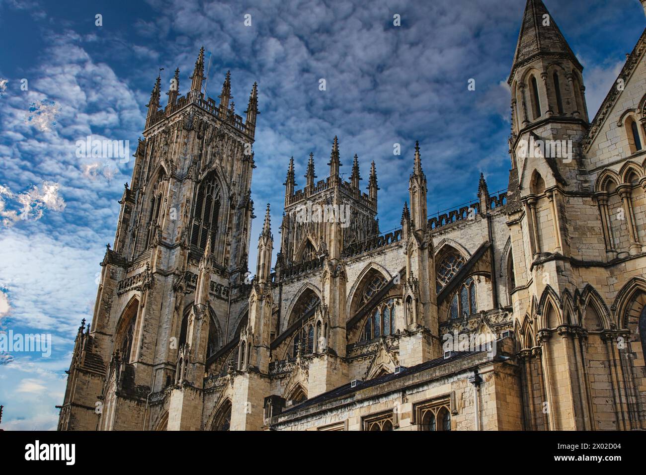 Gothic cathedral tower against a dramatic cloudy sky, showcasing ...
