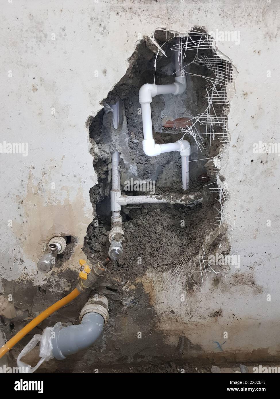 Damaged wall exposing burst water pipes after flood Stock Photo - Alamy