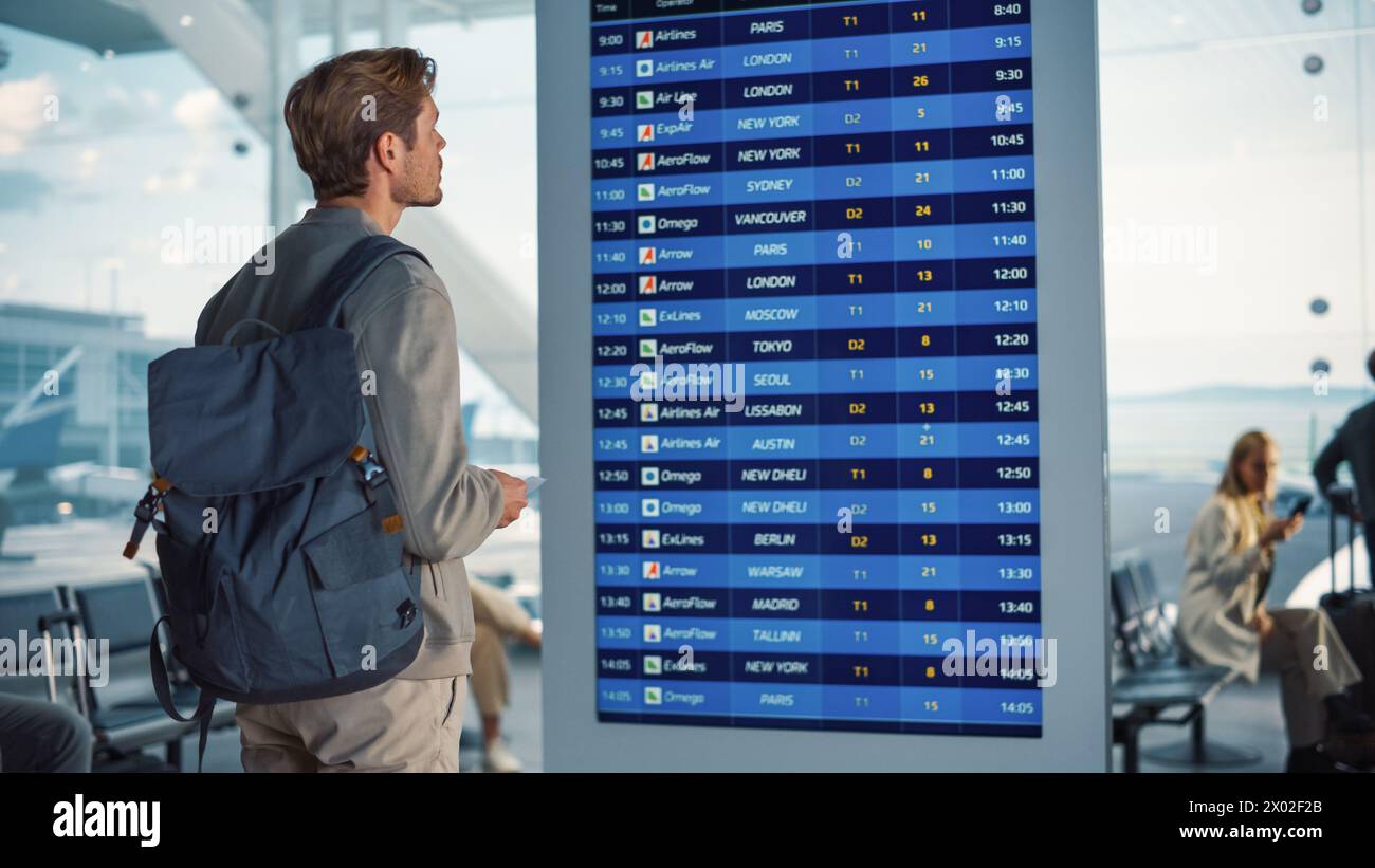 Airport Terminal: Young Man Looking at Arrival and Departure ...