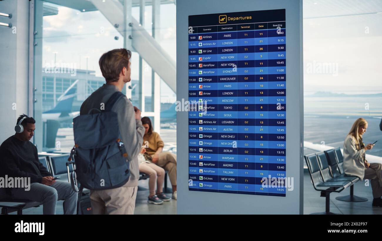 Airport Terminal: Young Man Looking at Arrival and Departure ...