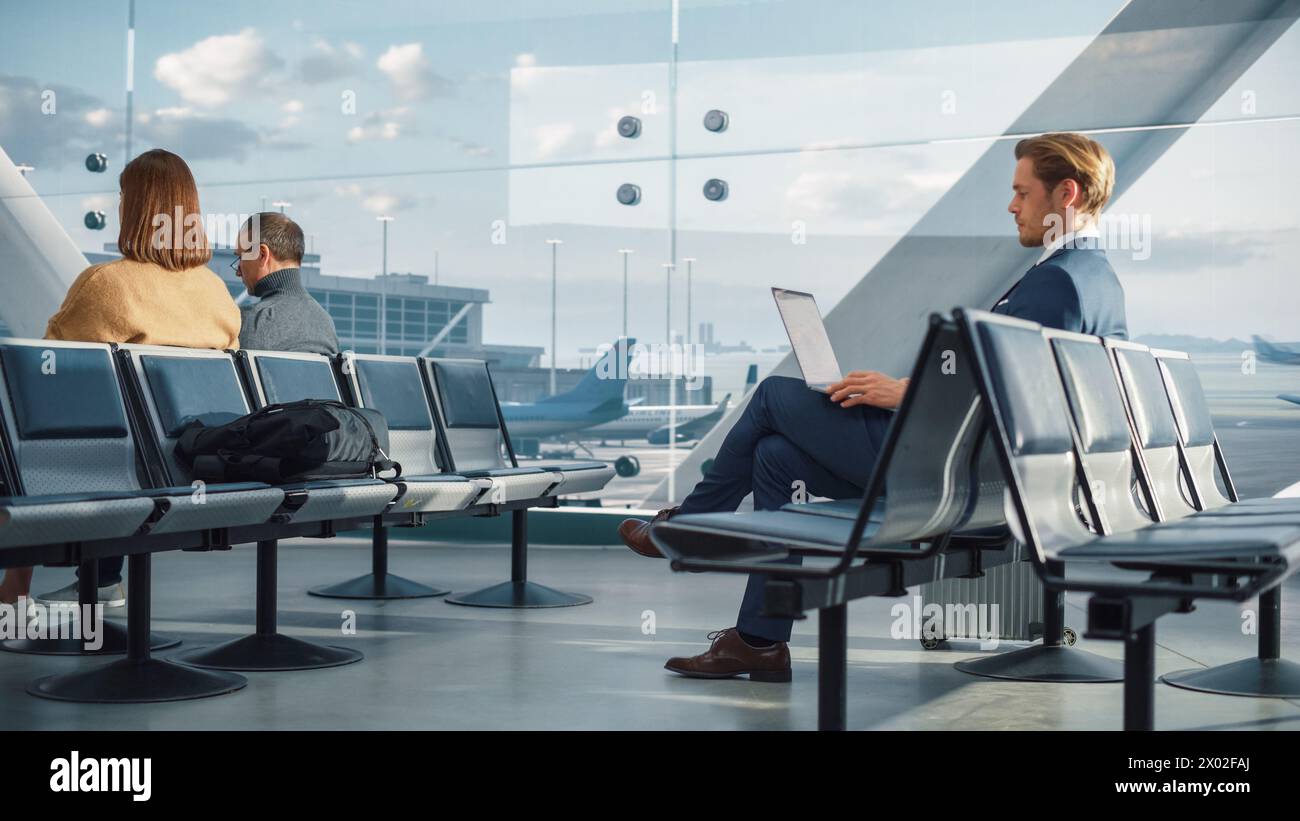 Airport Terminal: Businessman Uses Laptop Computer, Waiting for Flight ...
