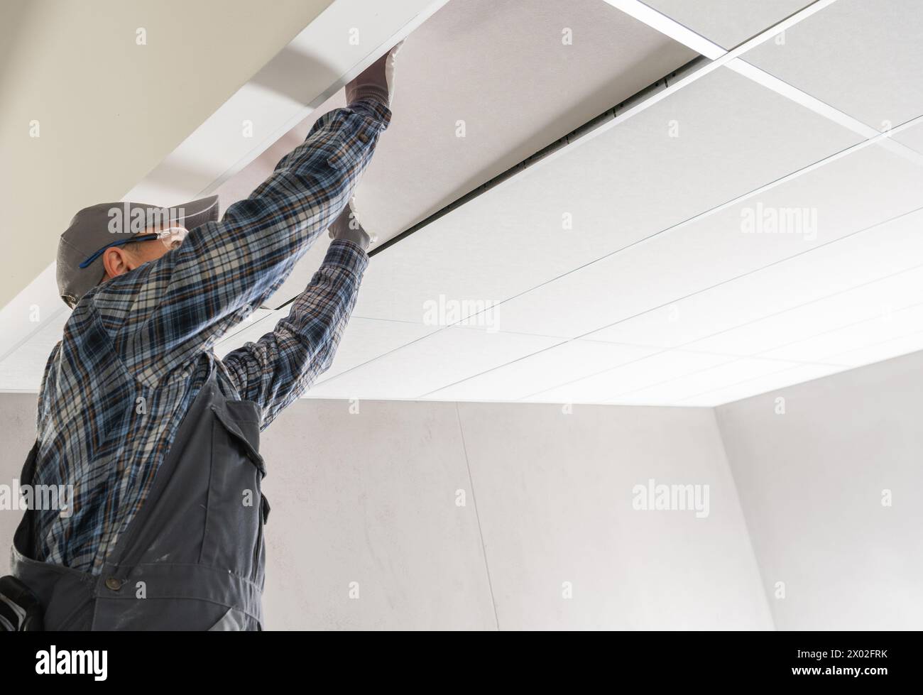 Construction Site Worker Installing Suspended Ceiling Inside a ...