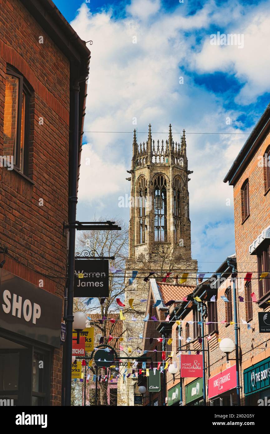 Quaint urban street with festive bunting leading to a historic church ...