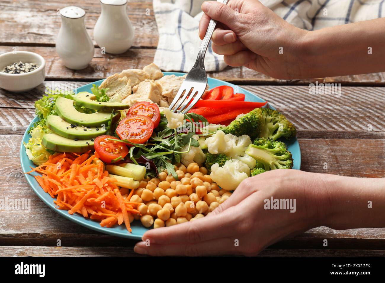 Balanced diet and healthy foods. Woman eating dinner at wooden table ...