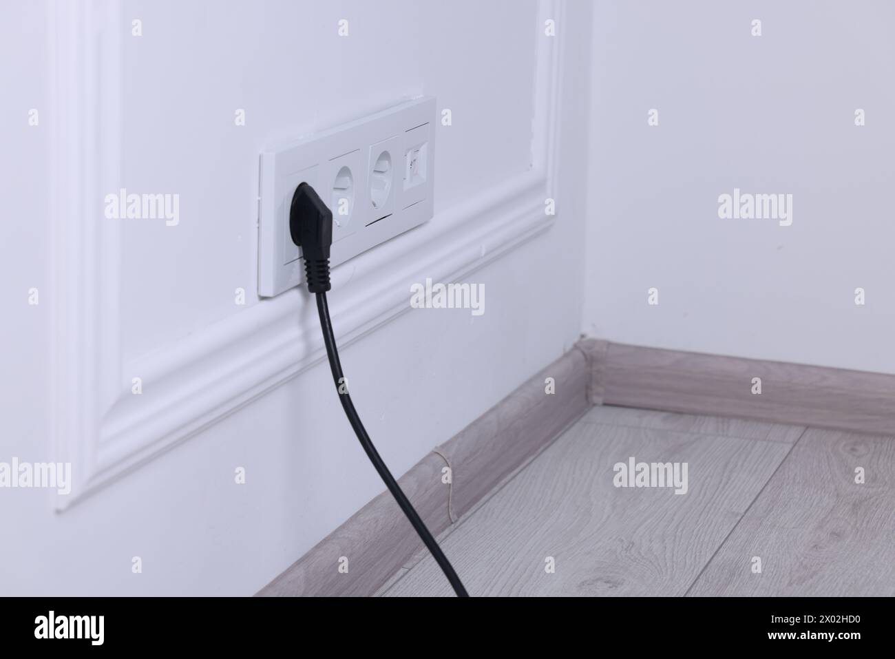 Power sockets and electric plug on white wall, space for text Stock ...