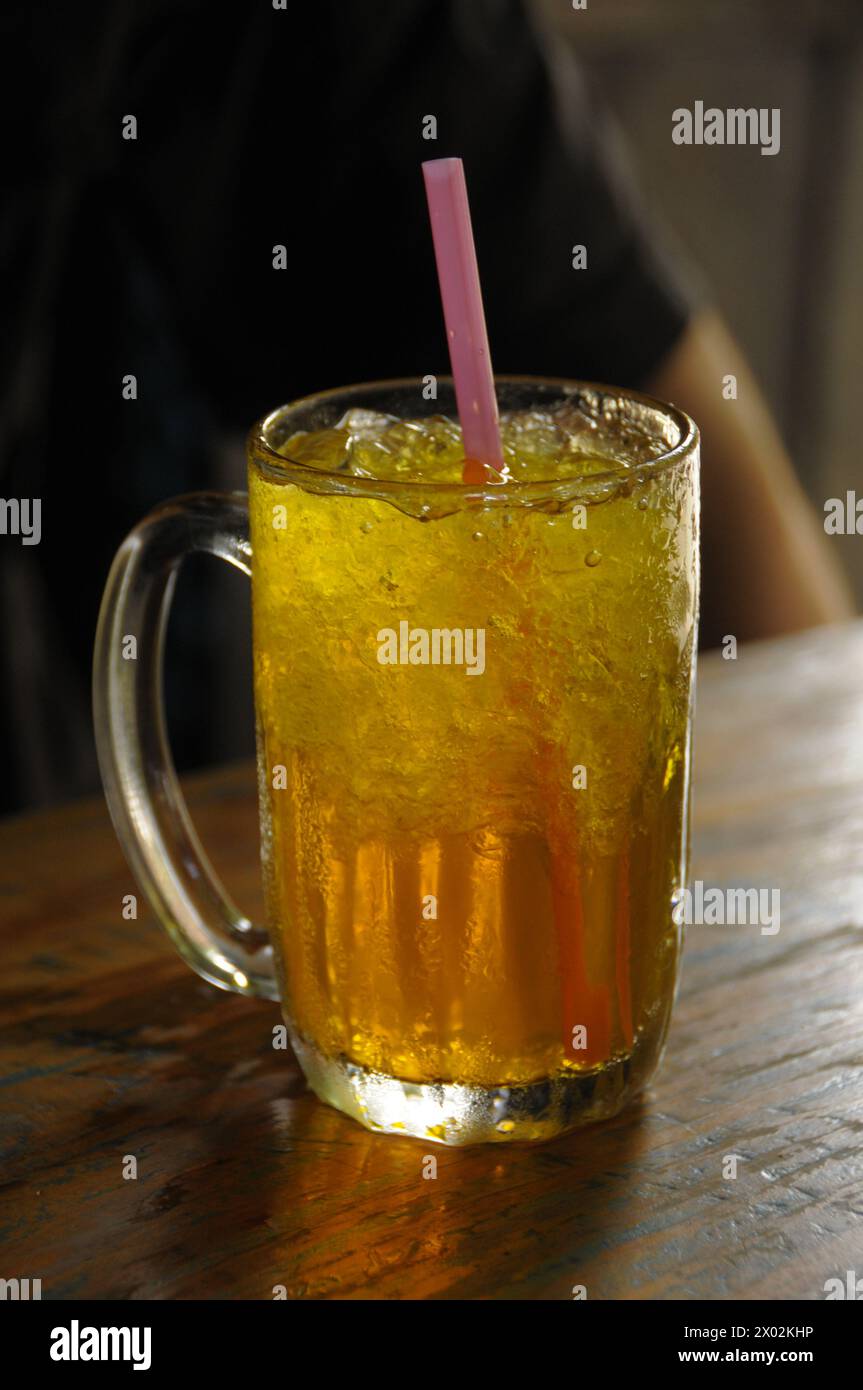 A glass of chrysanthemum iced tea in a street tea shop in Bangkok ...