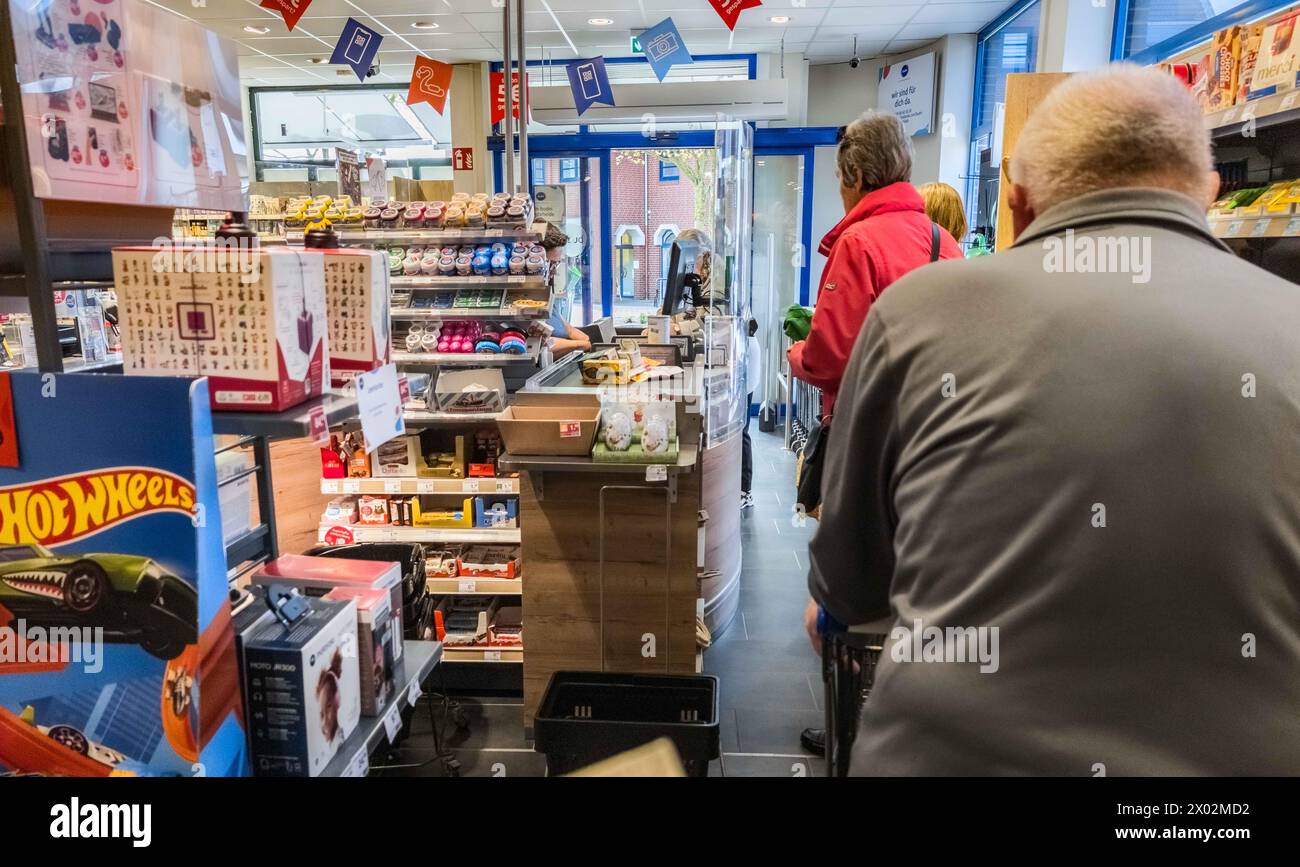 Hamburg, Germany. 09th Apr, 2024. Customers stand at the checkout in a ...