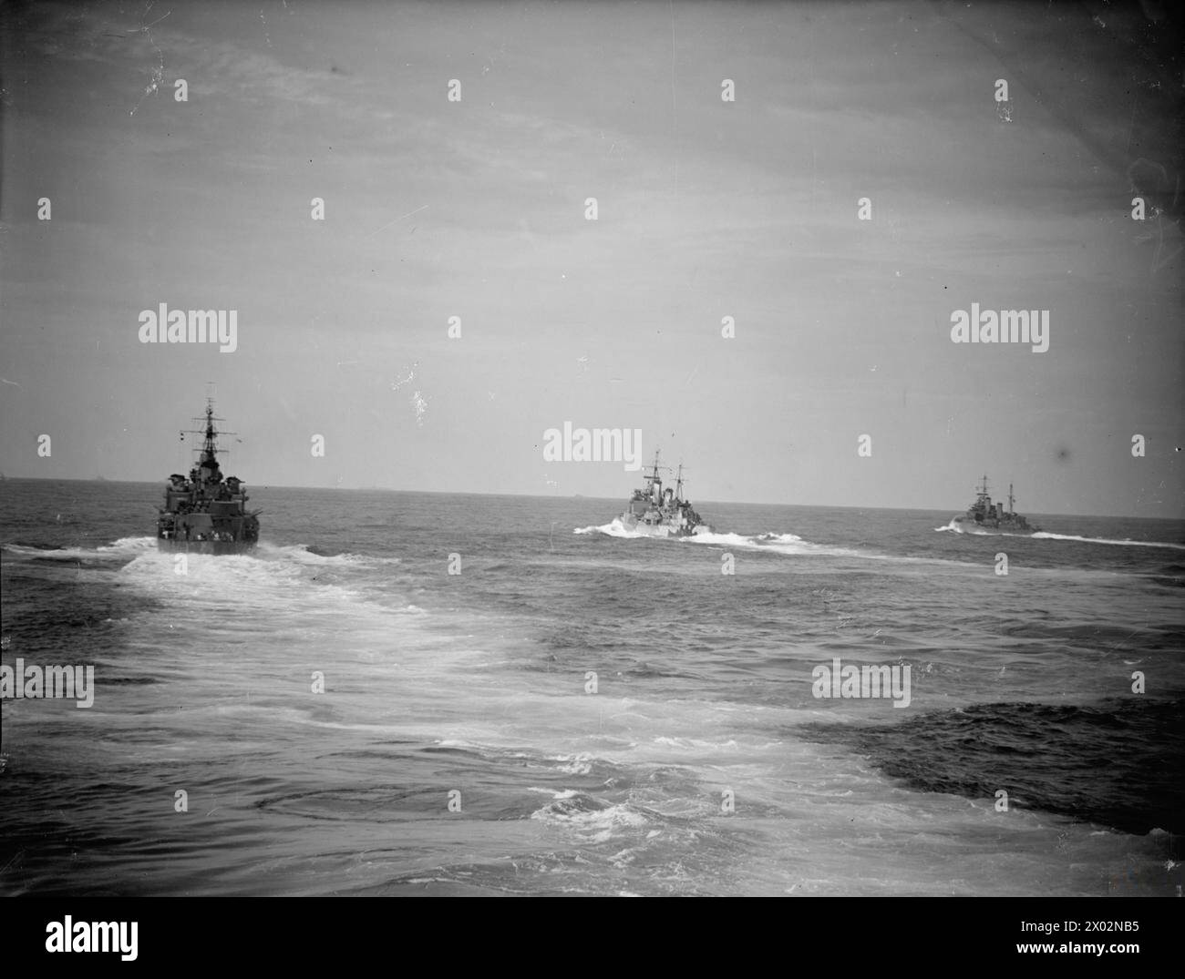 Three cruisers, HMS Edinburgh, HMS Sheffield, and HMS Kenya, escort a ...