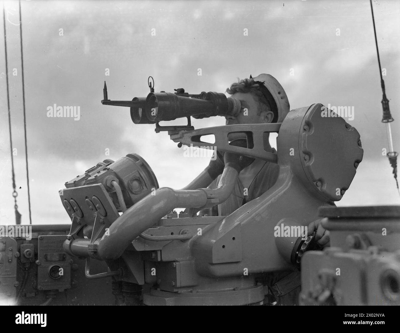 HMS MAURITIUS. JULY 1942. - A lookout scanning the horizon for ships or ...