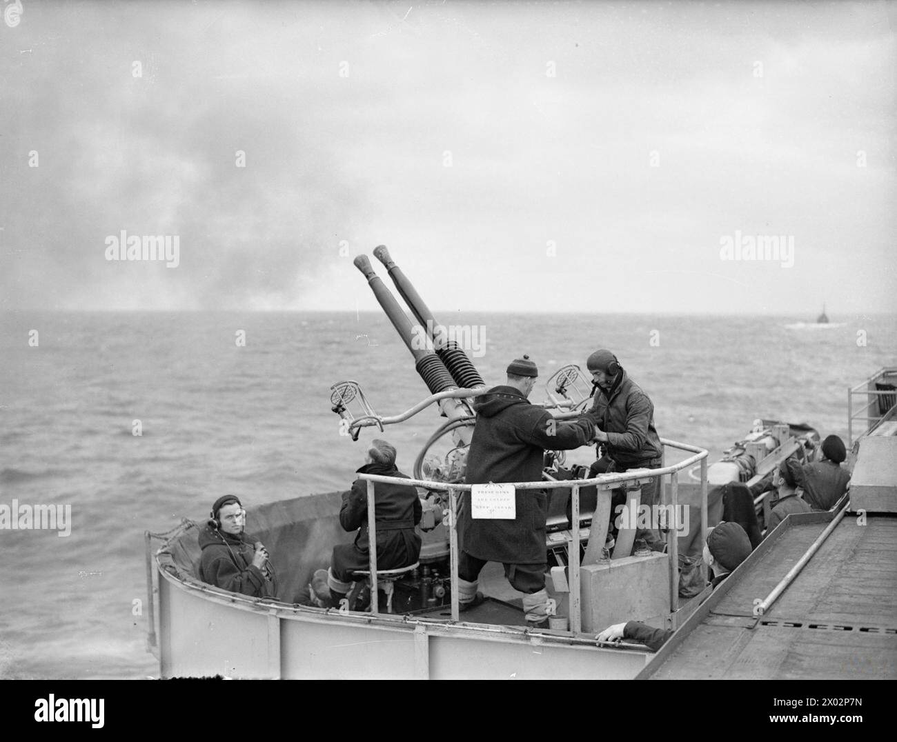 Gun crew operate twin 40mm Bofors anti-aircraft guns on HMS Tracker, an ...